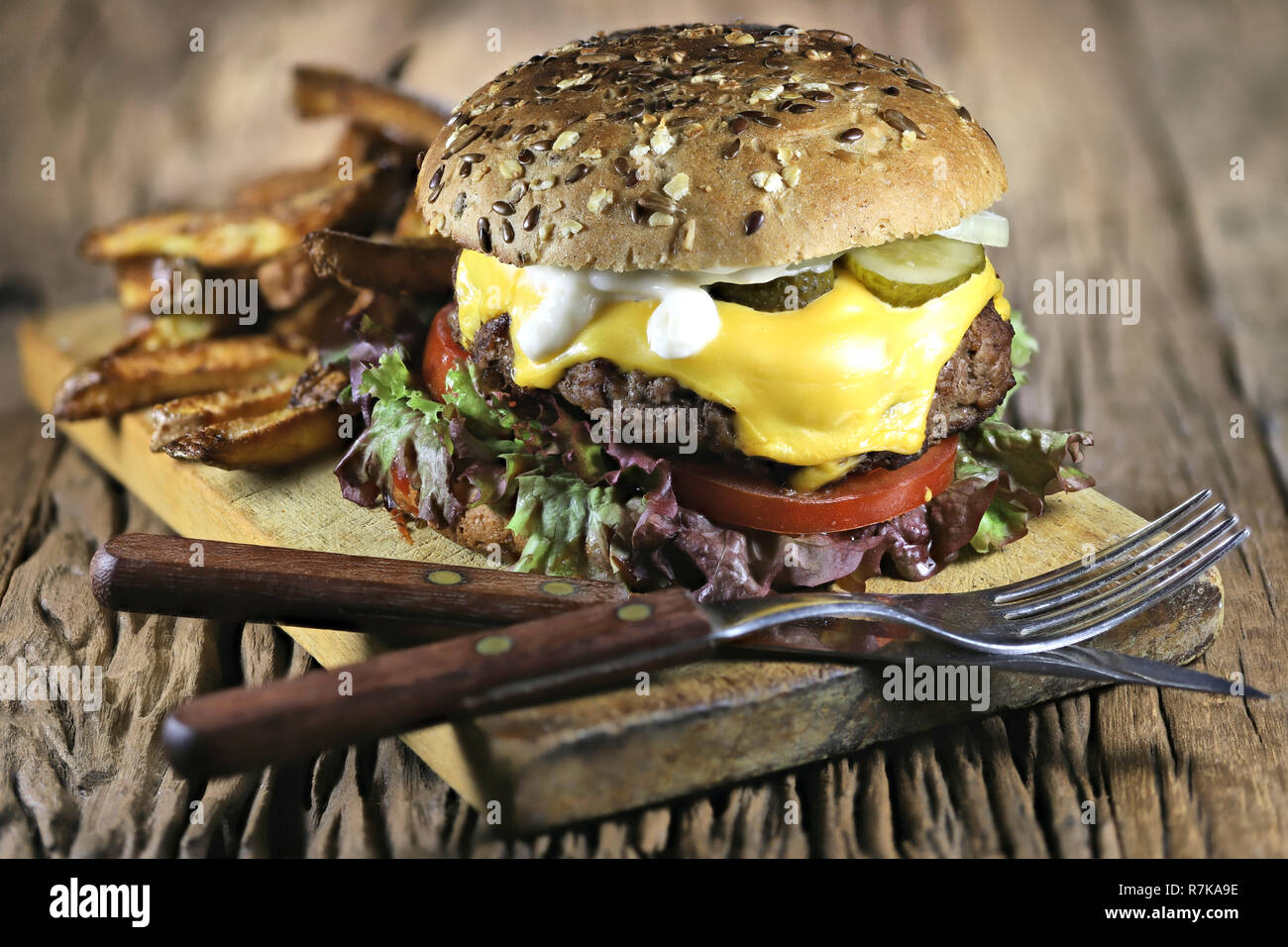 homemade cheeseburger and French fries on rustic wooden background ...