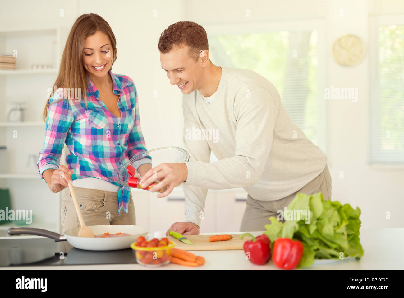 Beautiful young couple cooking healthy meal in the domestic kitchen ...