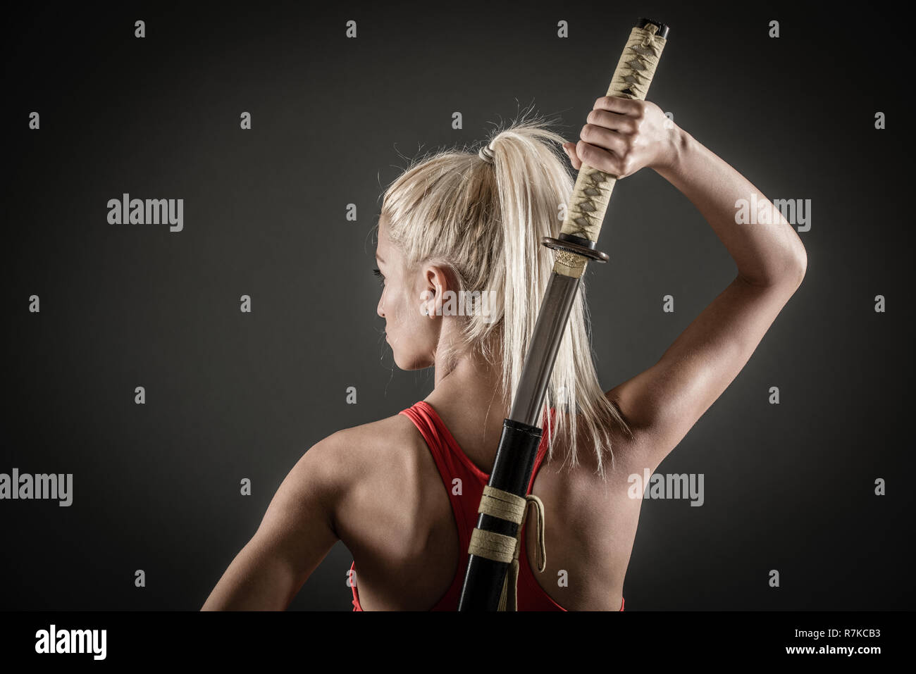 Pretty girl with a serious expression on her face drawing katana Stock ...