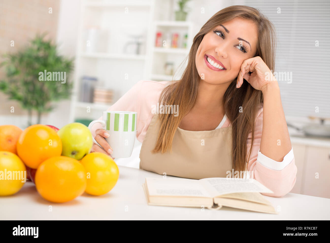 Beautiful young woman in the kitchen drinking coffee and thinking Stock ...