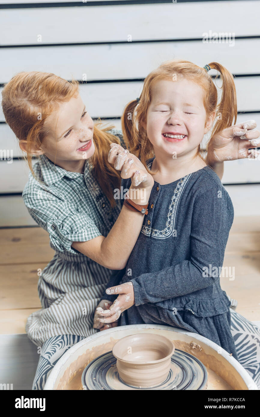 kids are smearing each other during the clay lesson Stock Photo - Alamy