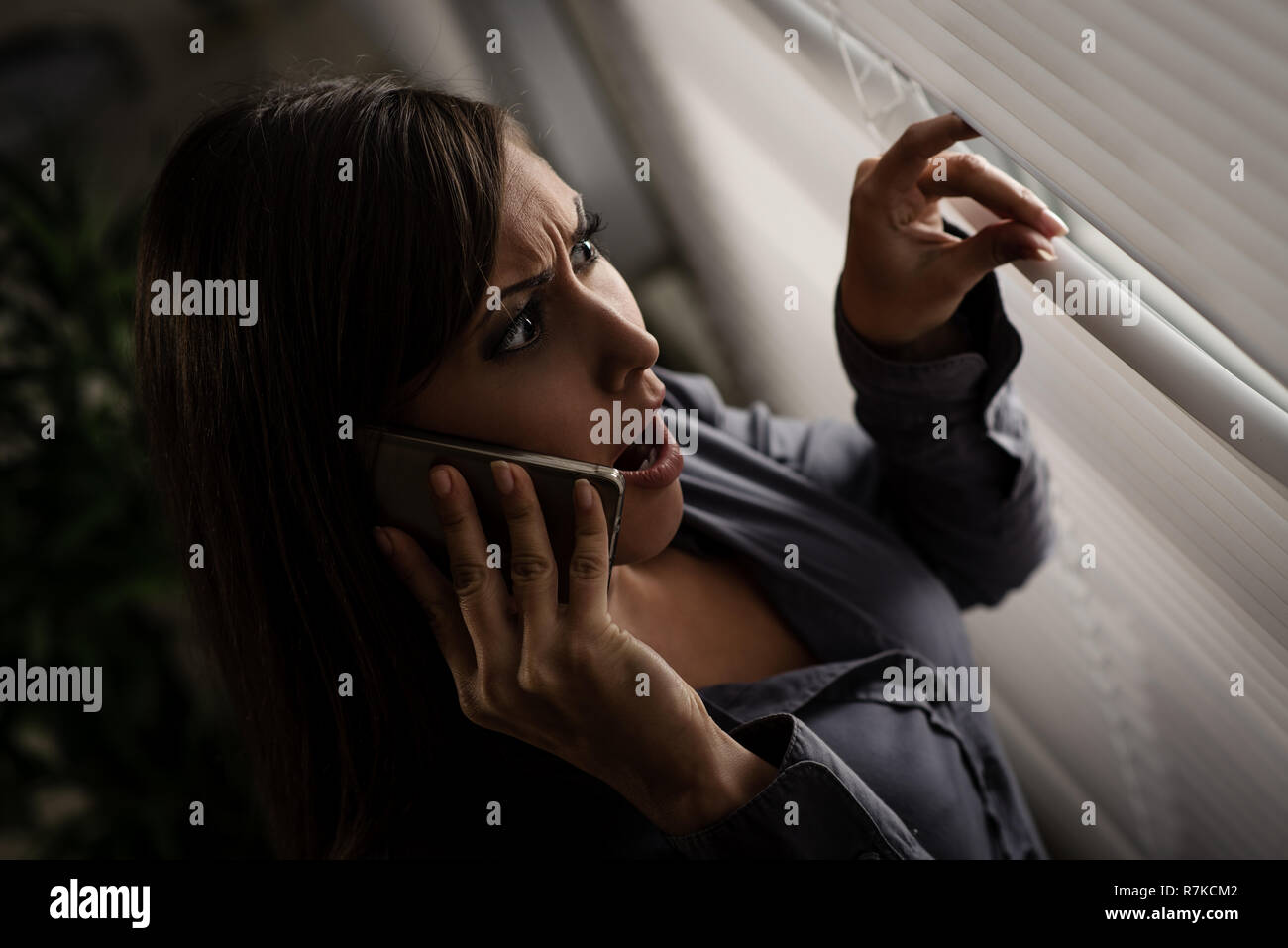 Young abused woman scared looking through the window seeking safety ...