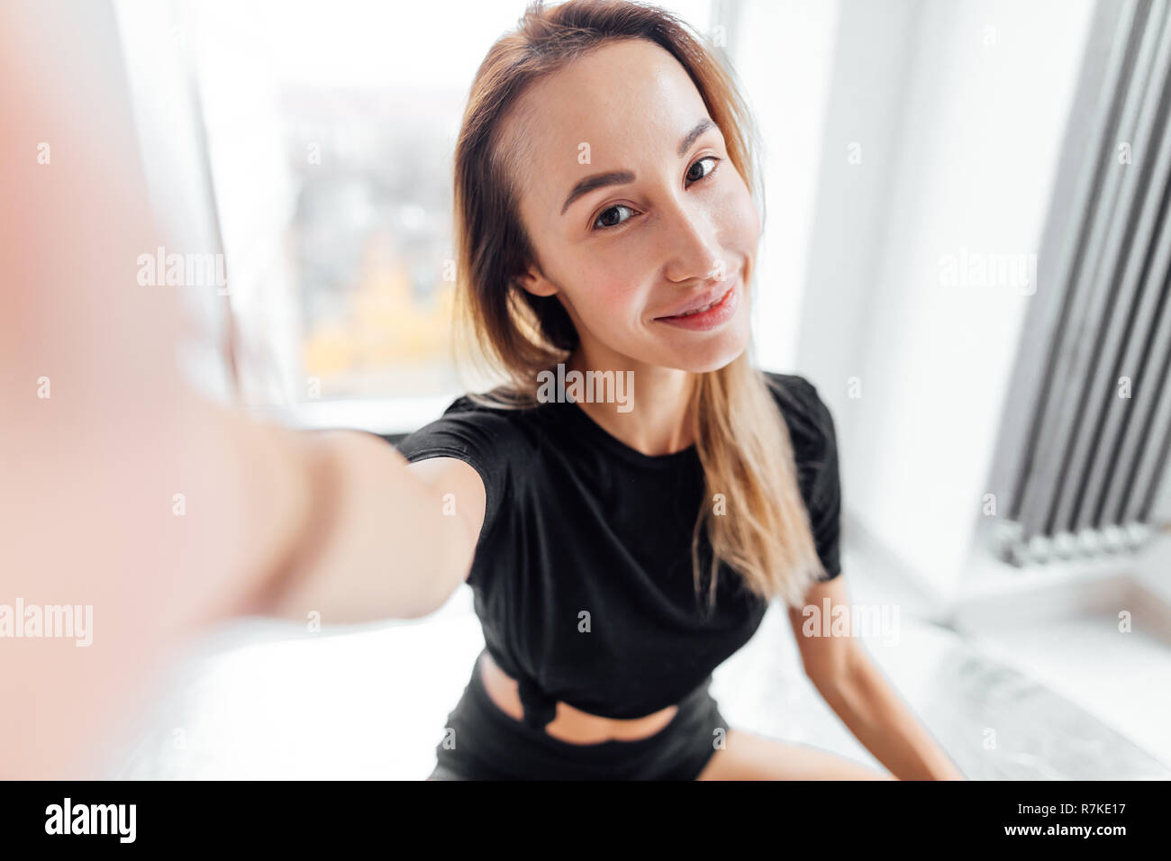 positive attractive sportswoman takinga selfie during the yoga training ...