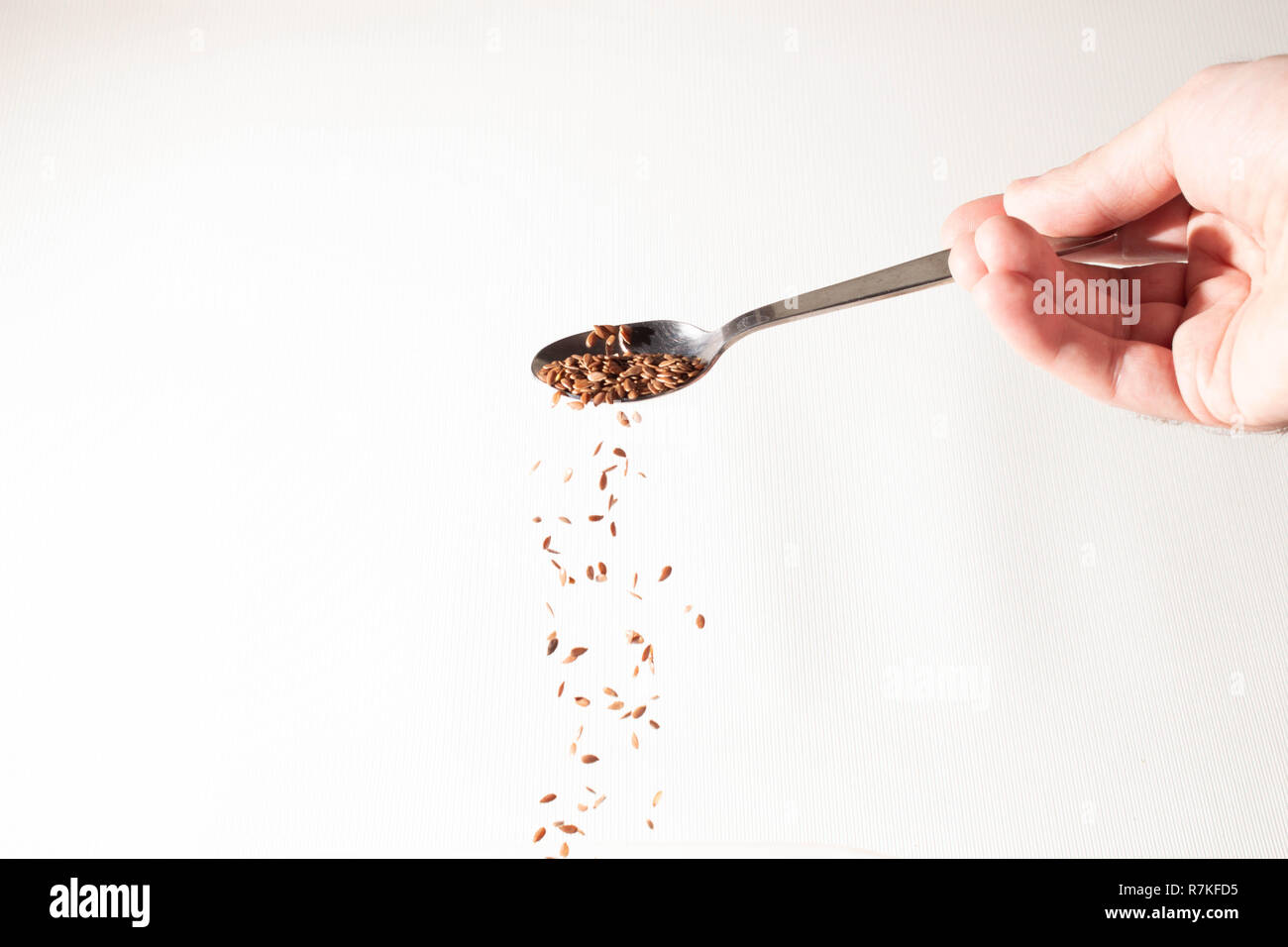 Flax seed handful falls down from the spoon. White Stock Photo - Alamy