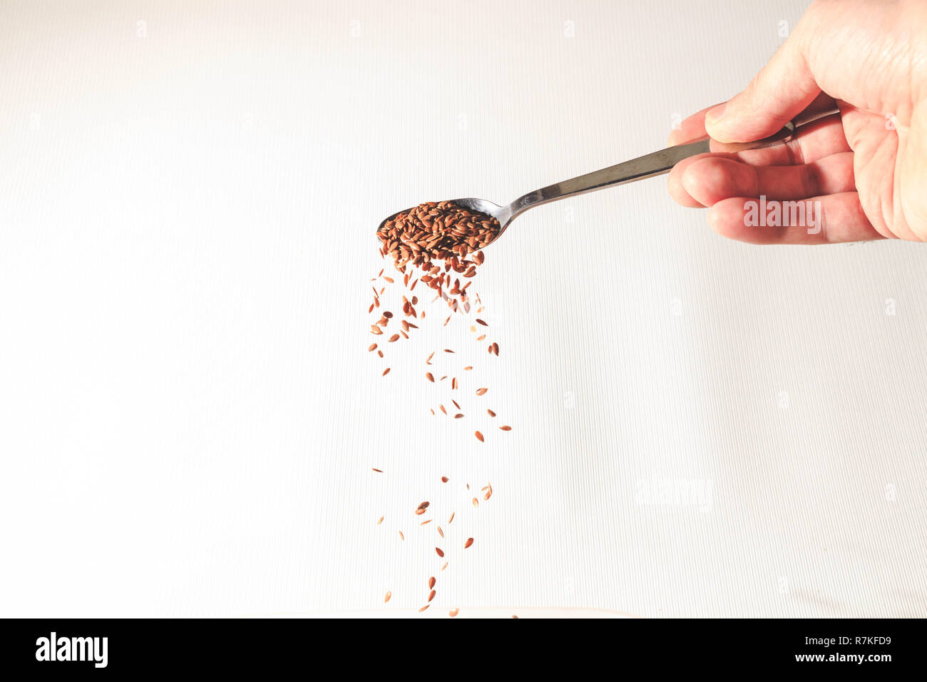 Flax seed handful falls down from the spoon. White Stock Photo - Alamy