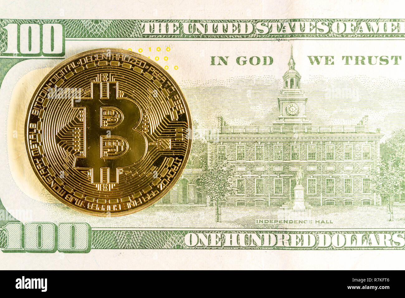 Bitcoin coin lies on a 100 dollar banknote Stock Photo - Alamy