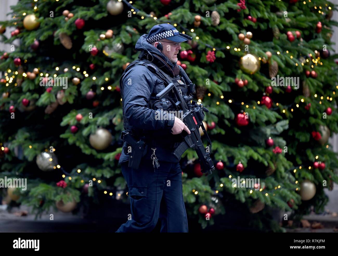 Armed Police officer passes the Christmas tree outside Number 10 ...
