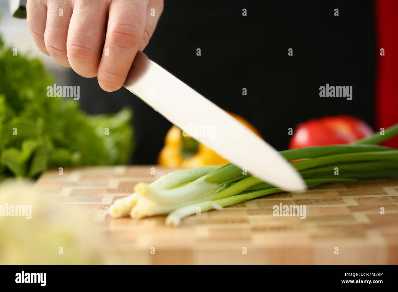 Cook holds knife in hand and cuts on Stock Photo - Alamy