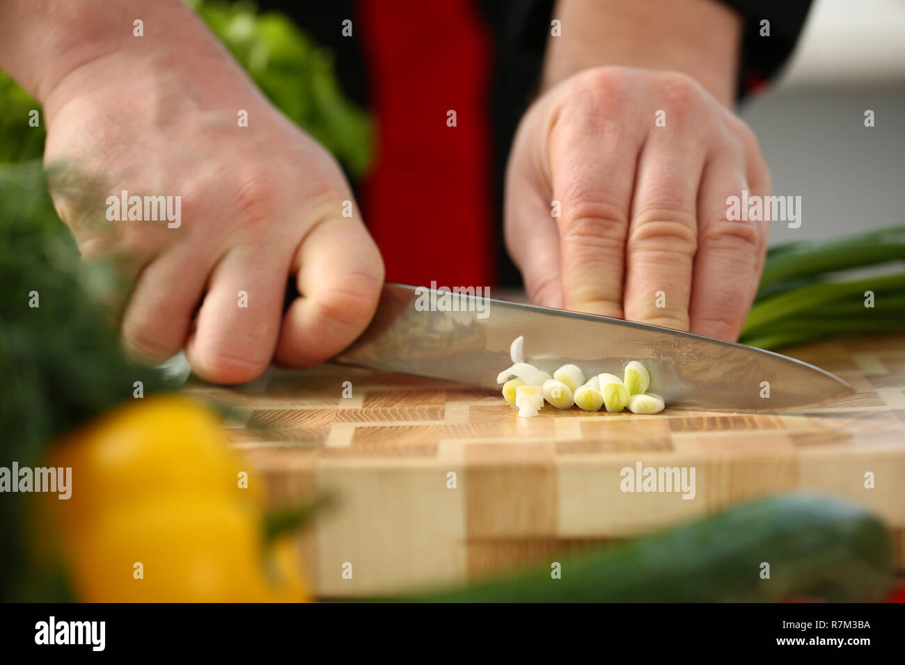 Cook holds knife in hand and cuts on Stock Photo - Alamy
