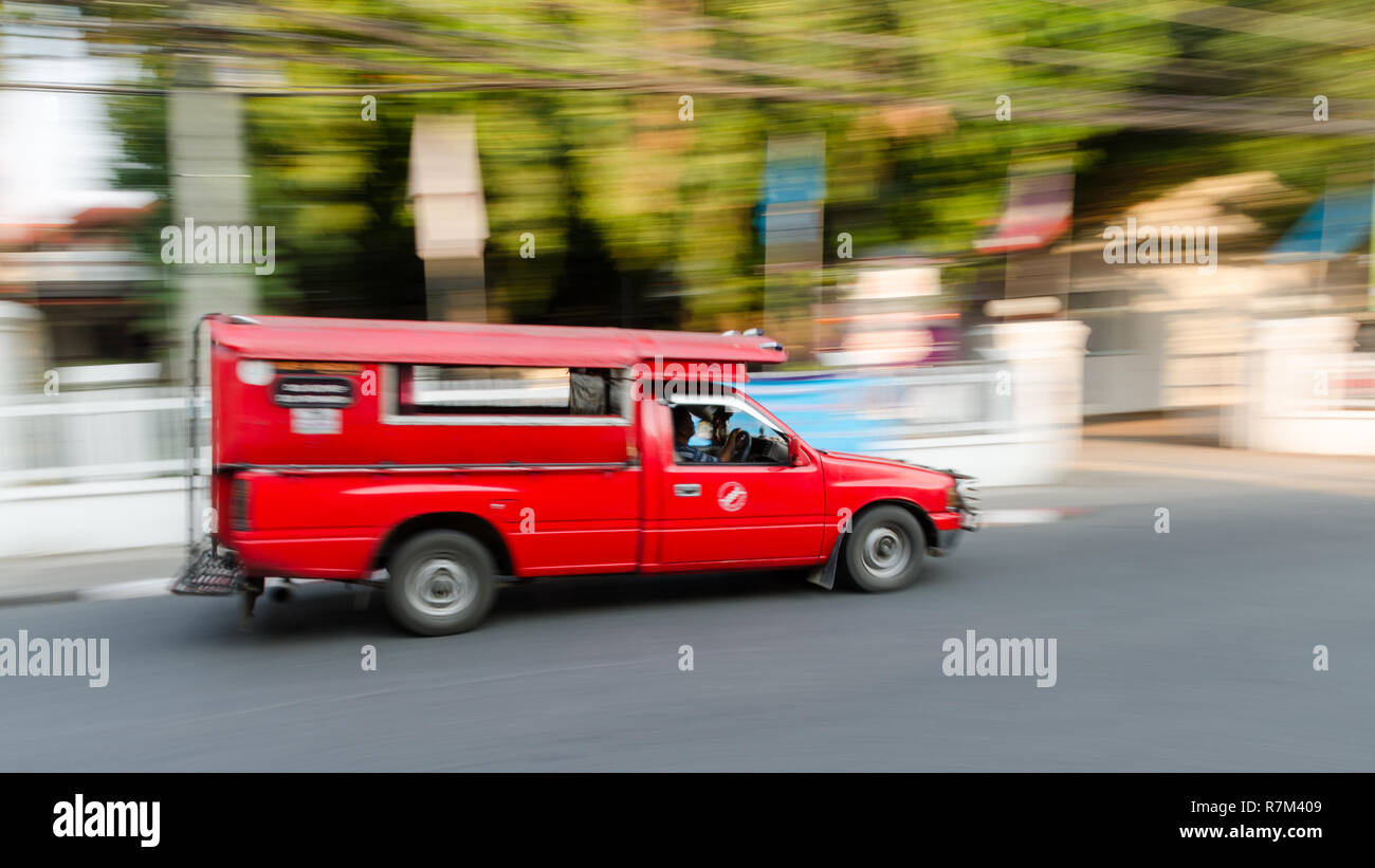 Panning shot of a red songthaew in Chiang Mai, Thailand Stock Photo - Alamy