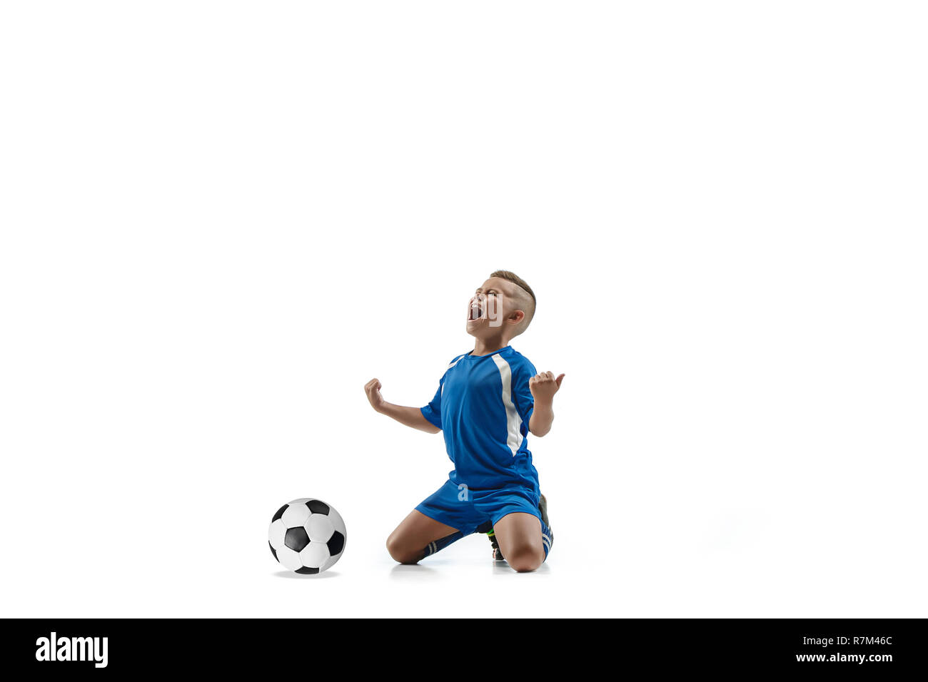 Young boy with soccer ball doing flying kick, isolated on white ...