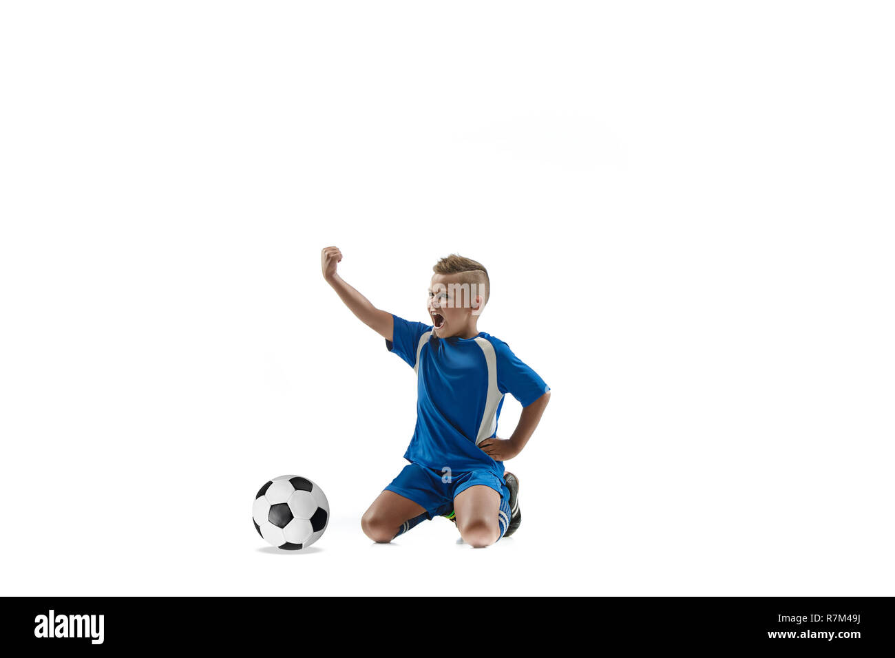 Young boy with soccer ball doing flying kick, isolated on white ...