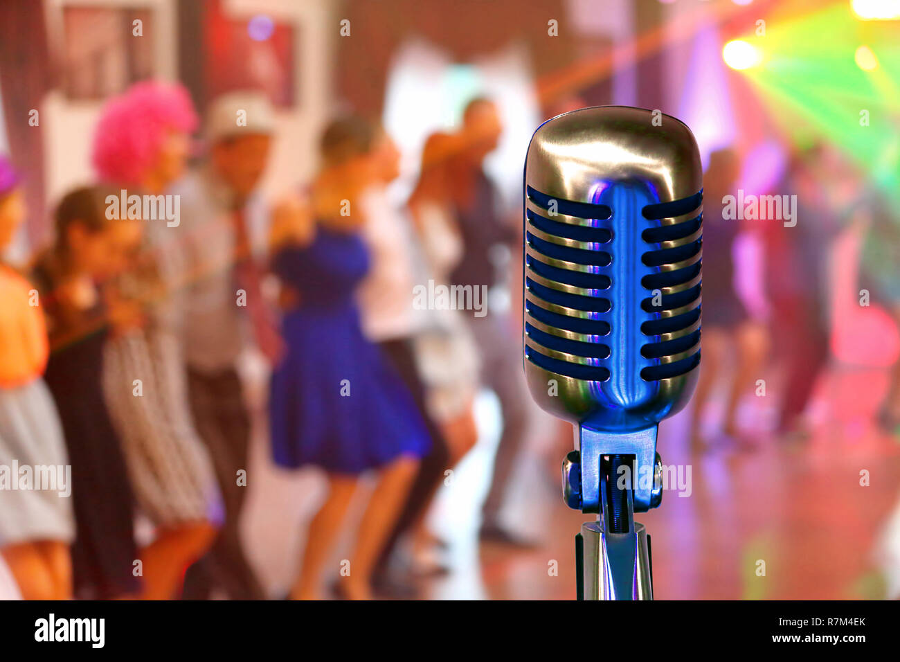 Retro microphone at concert with crowd dancing people and empty space ...