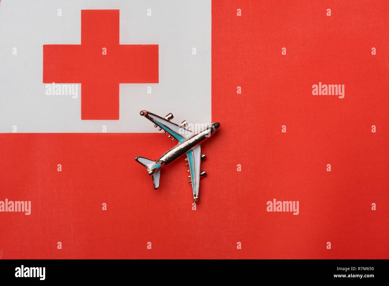 Plane over the flag of Tonga, the concept of journey. Toy plane on the ...