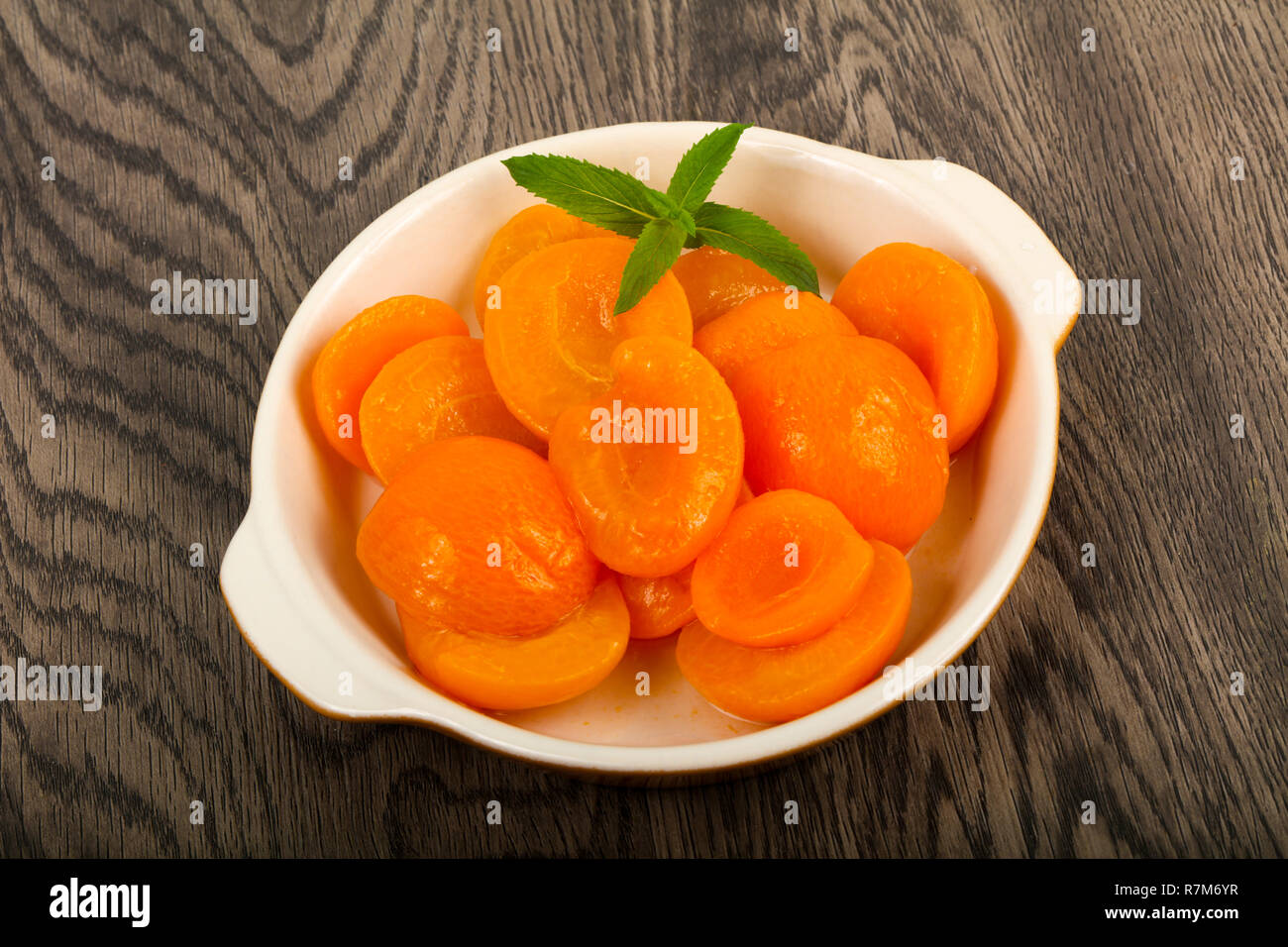 Canned apricots with mint leaves Stock Photo - Alamy