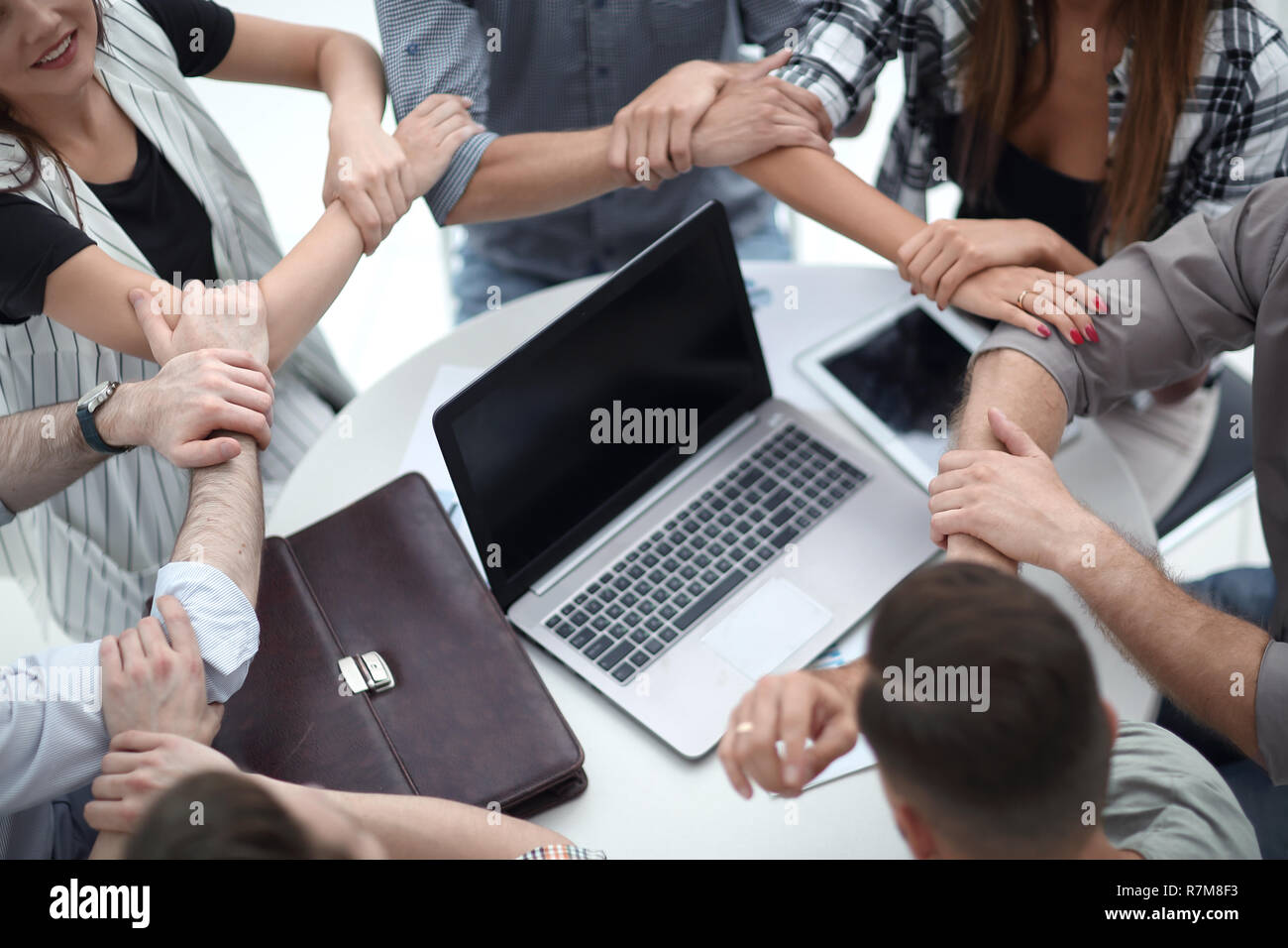 business team forms a circle of hands in the workplace Stock Photo - Alamy