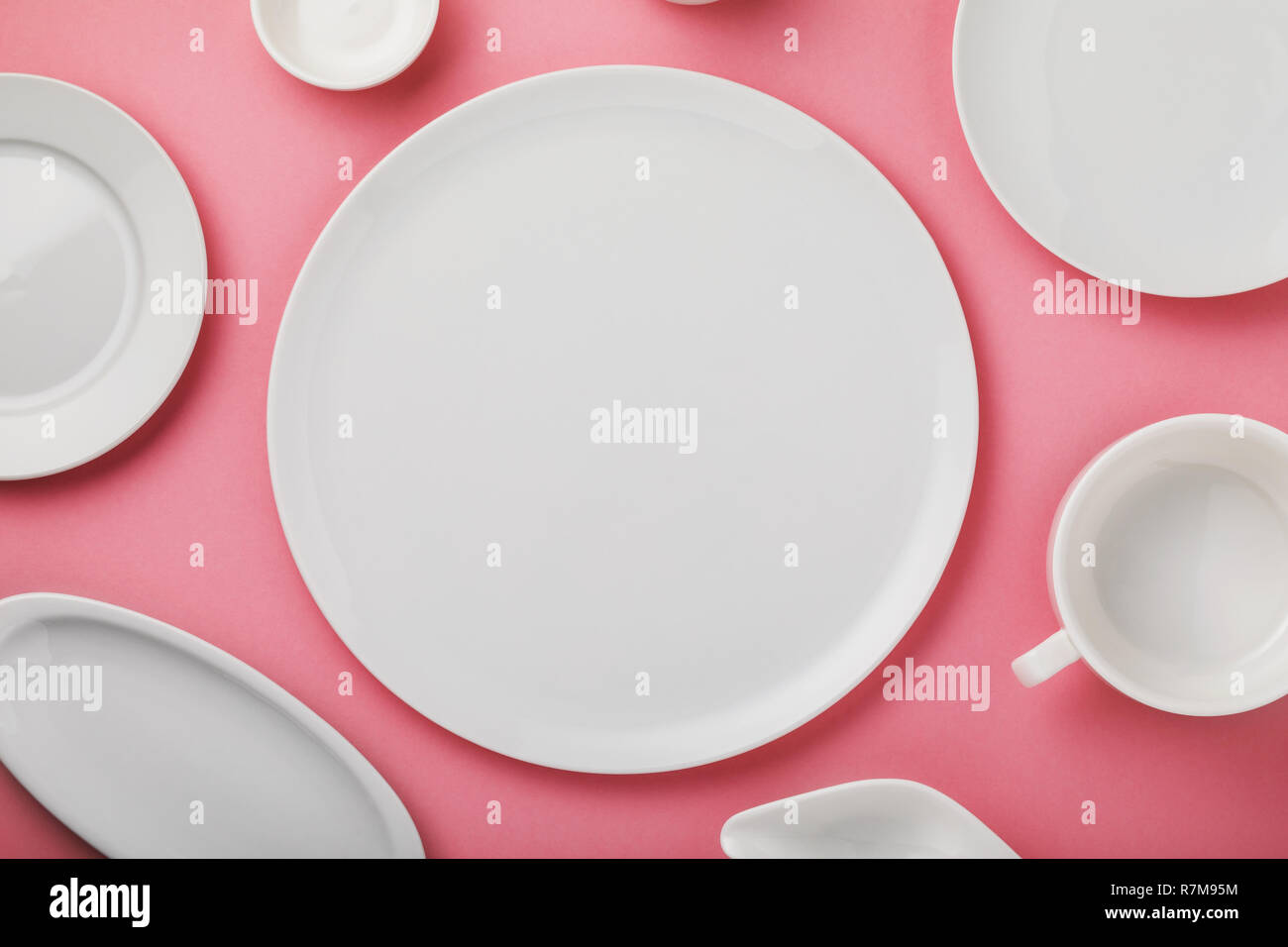 White ceramic dishes on the pink table, top view Stock Photo - Alamy