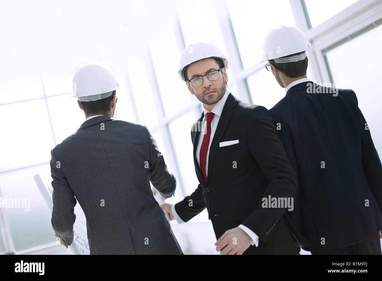 rear view.portrait of the architect on the glass office background ...
