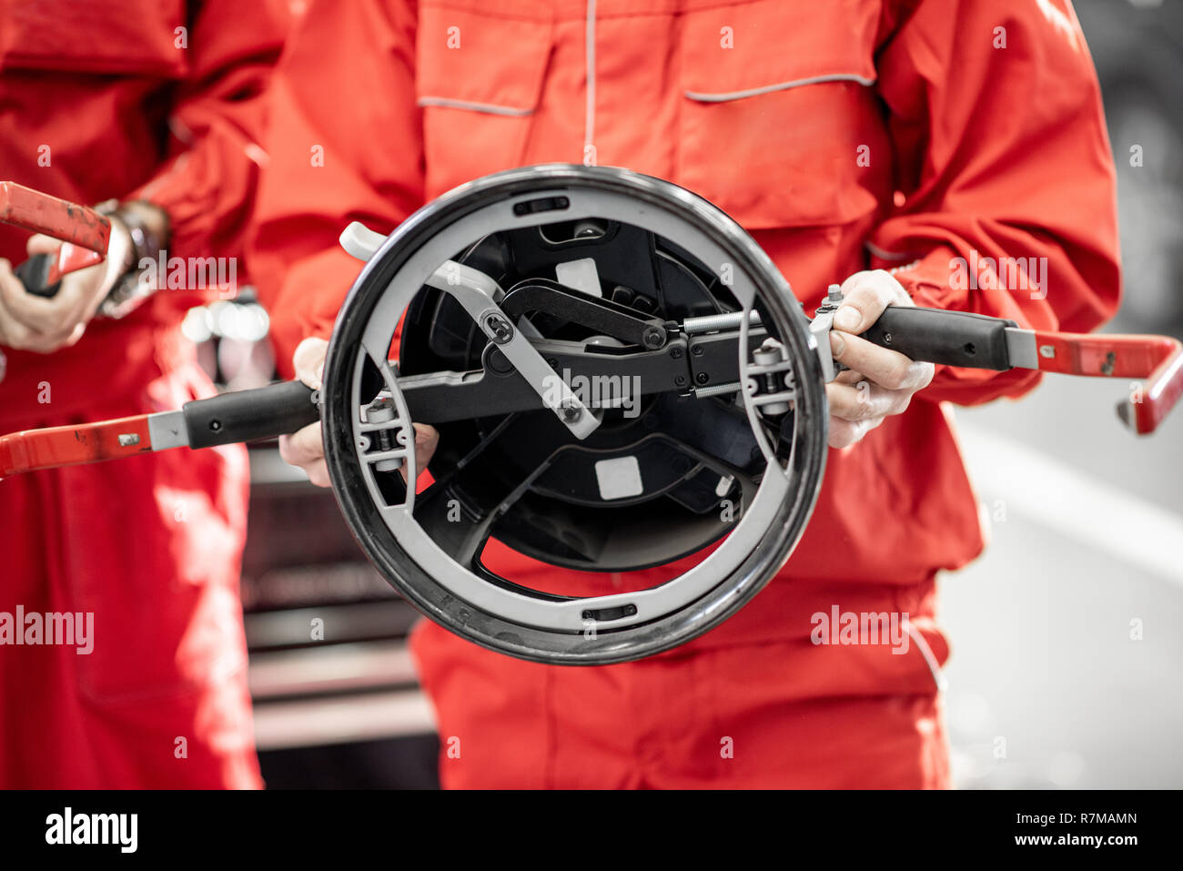 Auto mechanic holding disk for wheel alignment at the car service ...