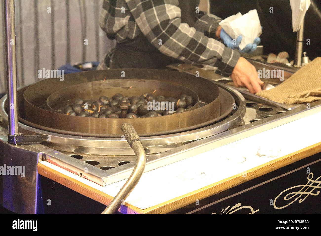 Chestnuts being roasted in a big pan by a peddler on a stand in Bristol ...