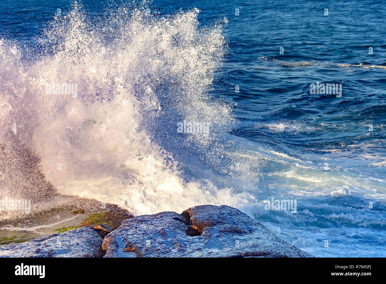 Waves crashing against rocks with spray and splashing water Stock Photo ...