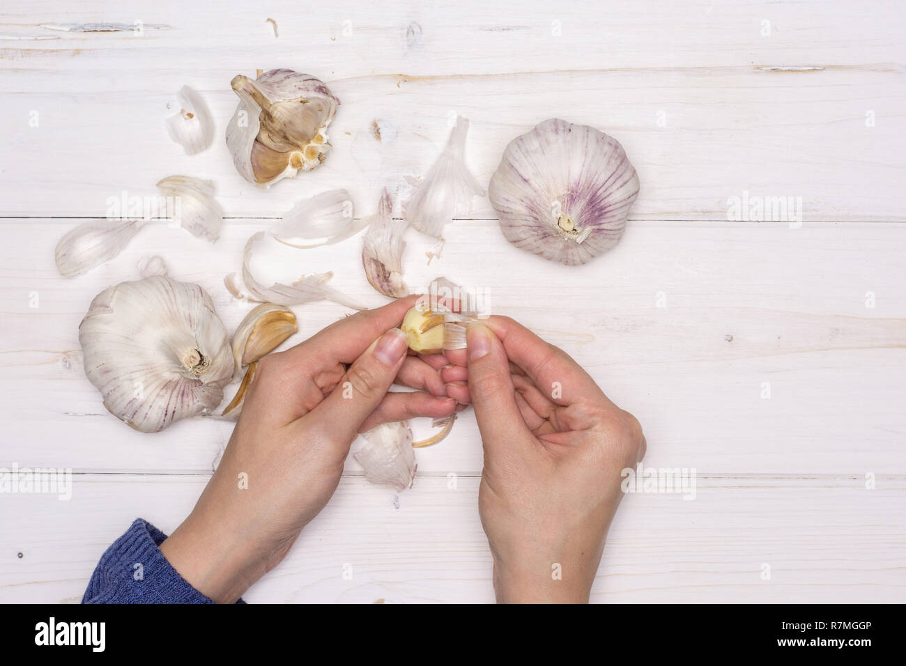 Woman hands are spliting garlic cloves. recipe step by step baked ...