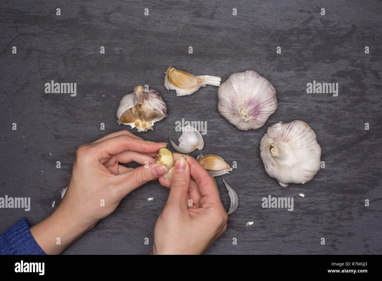 Woman hands are spliting garlic cloves. recipe step by step baked ...