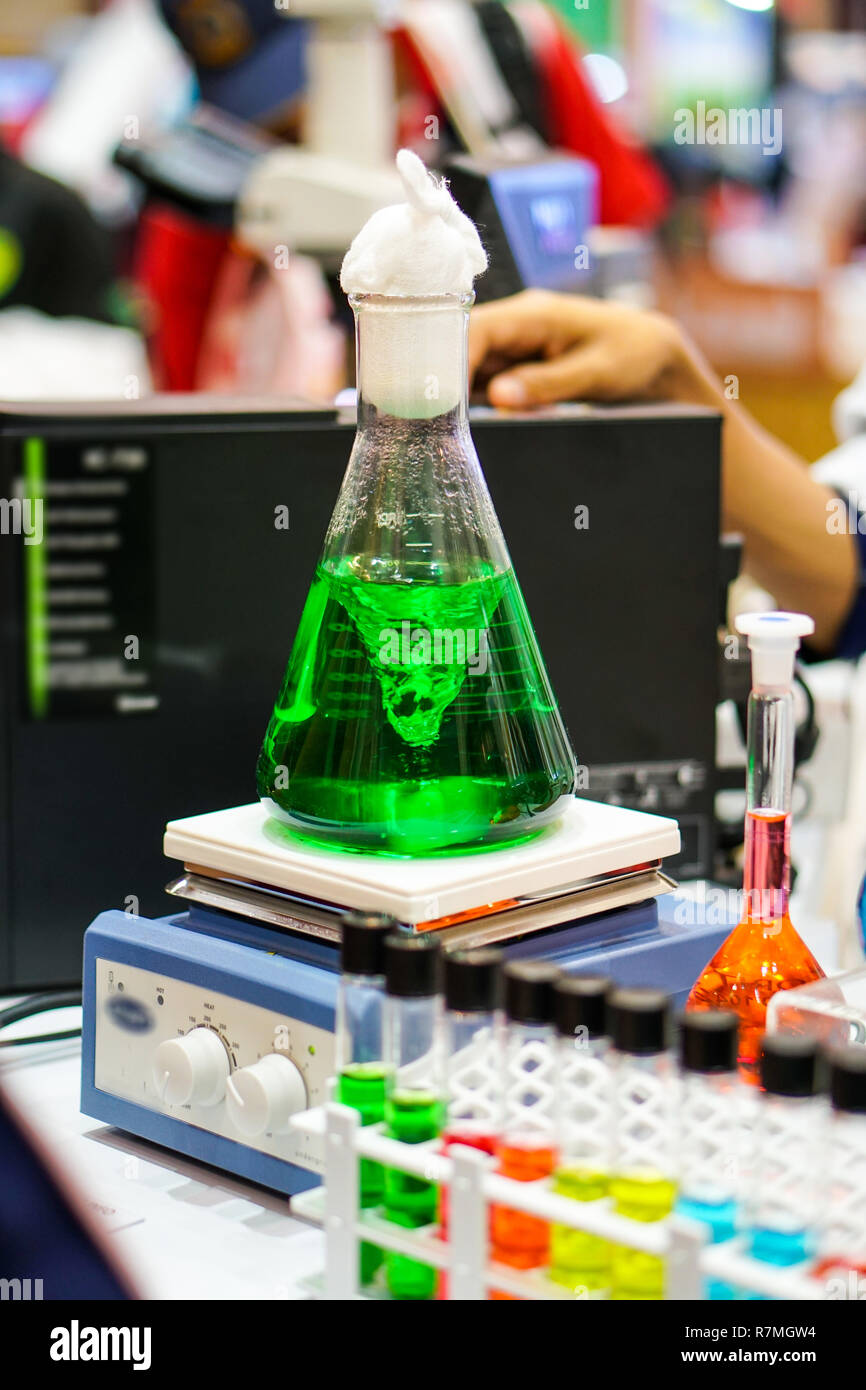 Magnetic laboratory agitators. The green liquid is mixed in a conical ...