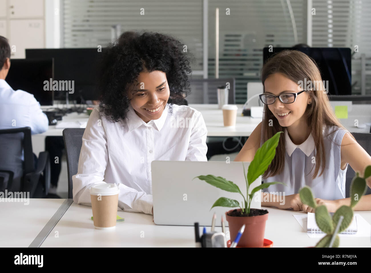 Colleagues working at same task on laptop together Stock Photo - Alamy