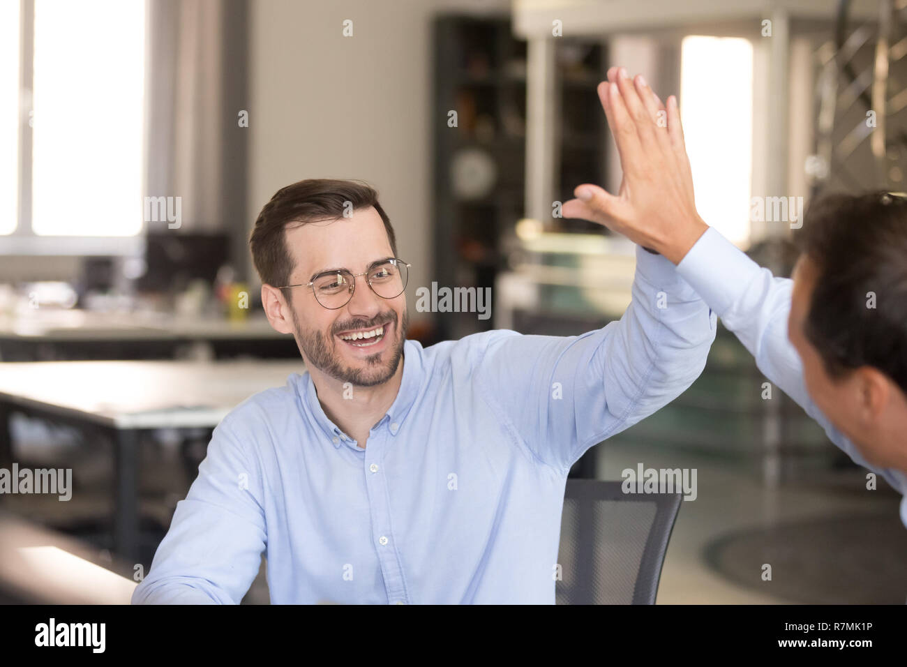 Happy male employee giving high five to colleague Stock Photo - Alamy
