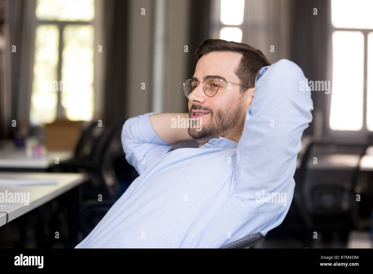 Confident businessman relaxing leaning back at workplace Stock Photo ...