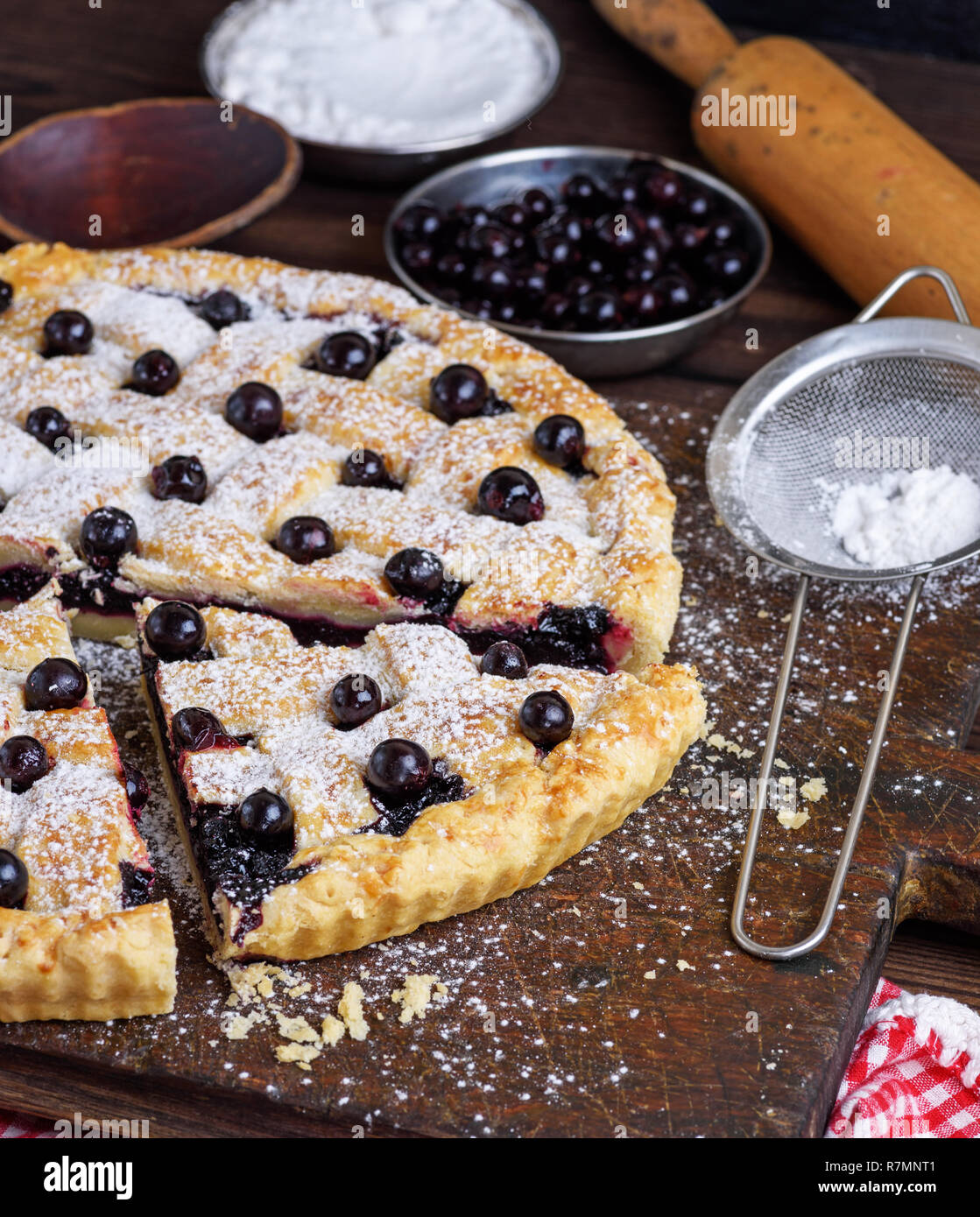 baked round black currant cake and powdered with icing sugar, top view ...