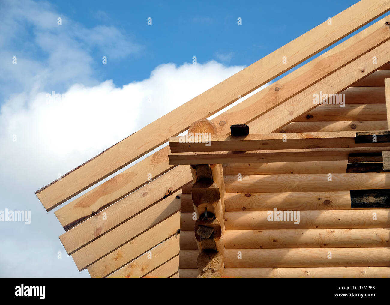 Process of wooden house straight roof slope mounting front view. Wooden ...