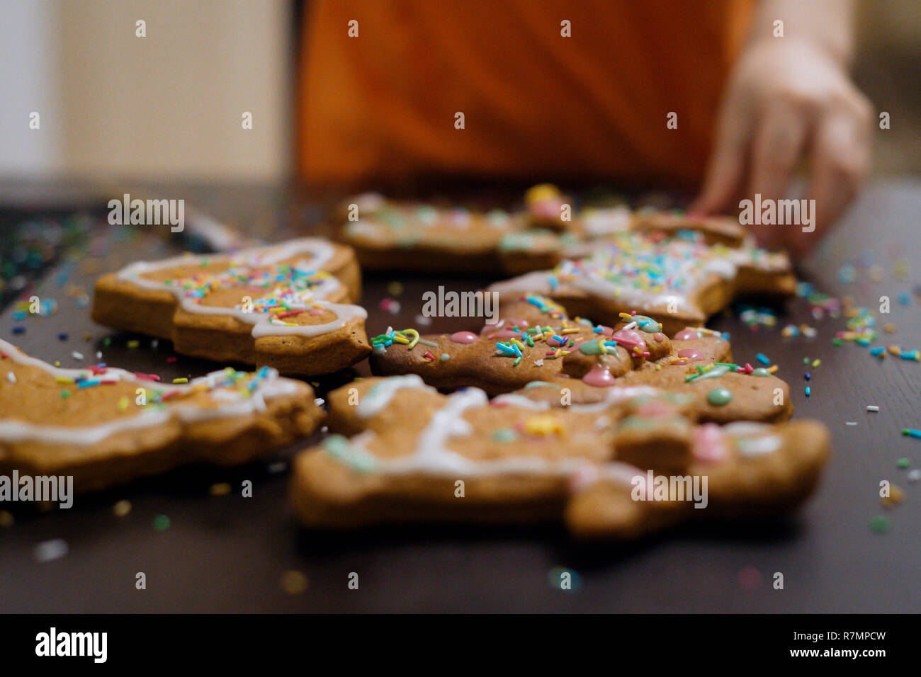 Christmas bakery. Friends decorating freshly baked gingerbread cookies ...