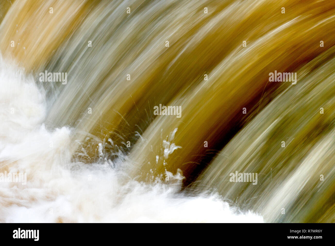 An abstract image of the Elliot Water in spate as it flows over a weir ...