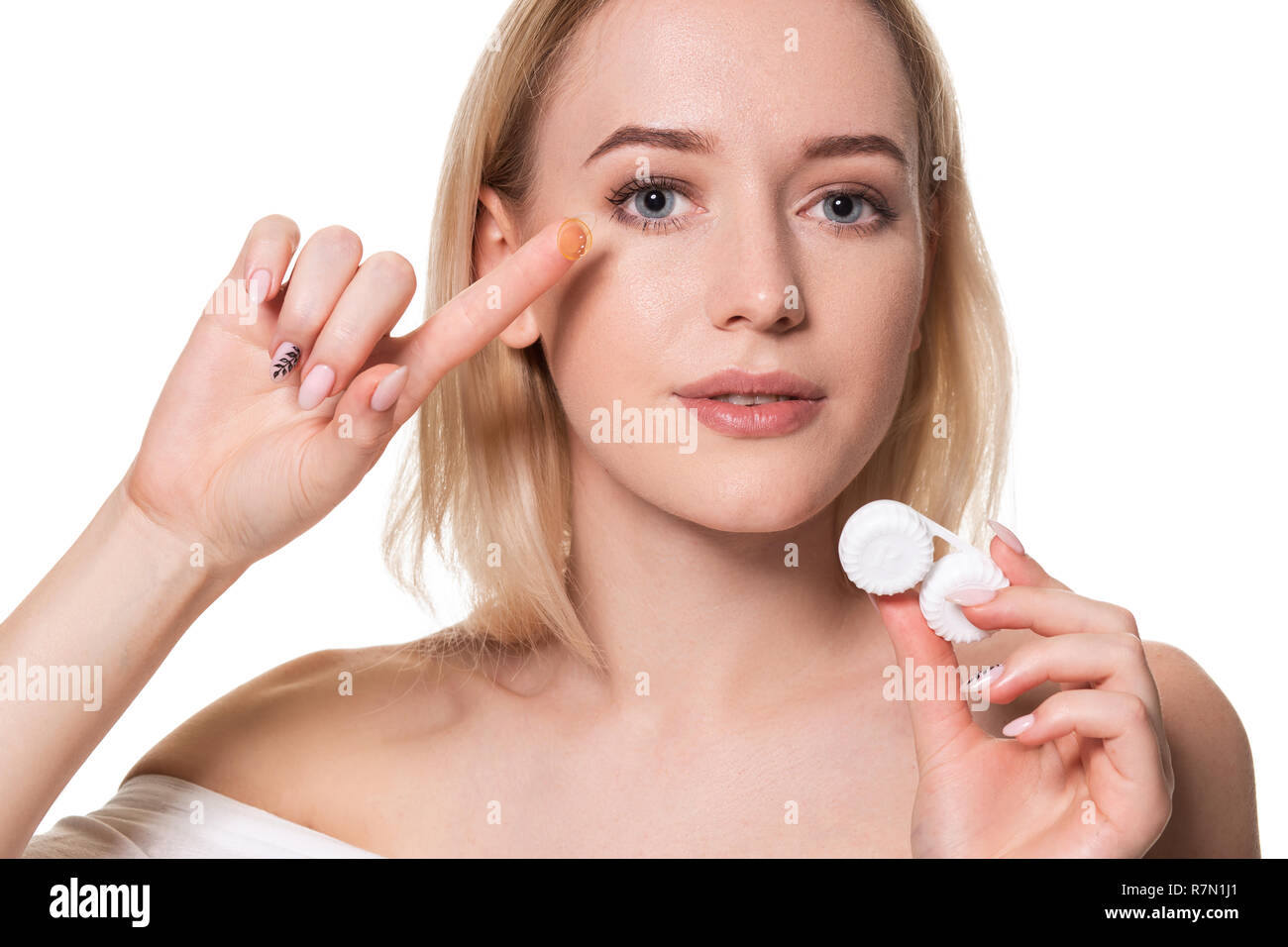 Young woman holding contact lenses cases and lens in front of her face ...