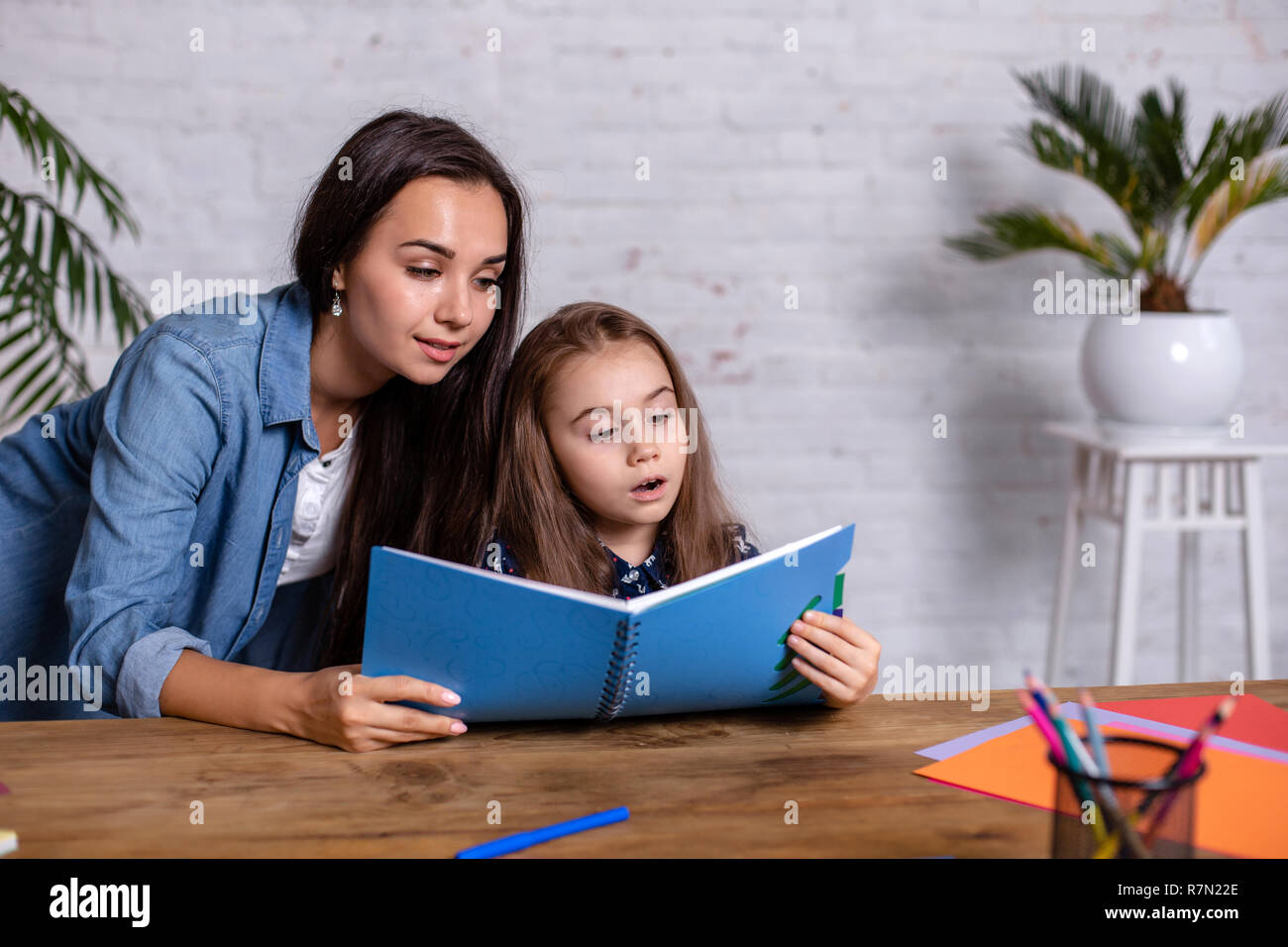 Mom helps my daughter do her homework in the kitchen. Mom and daughter ...