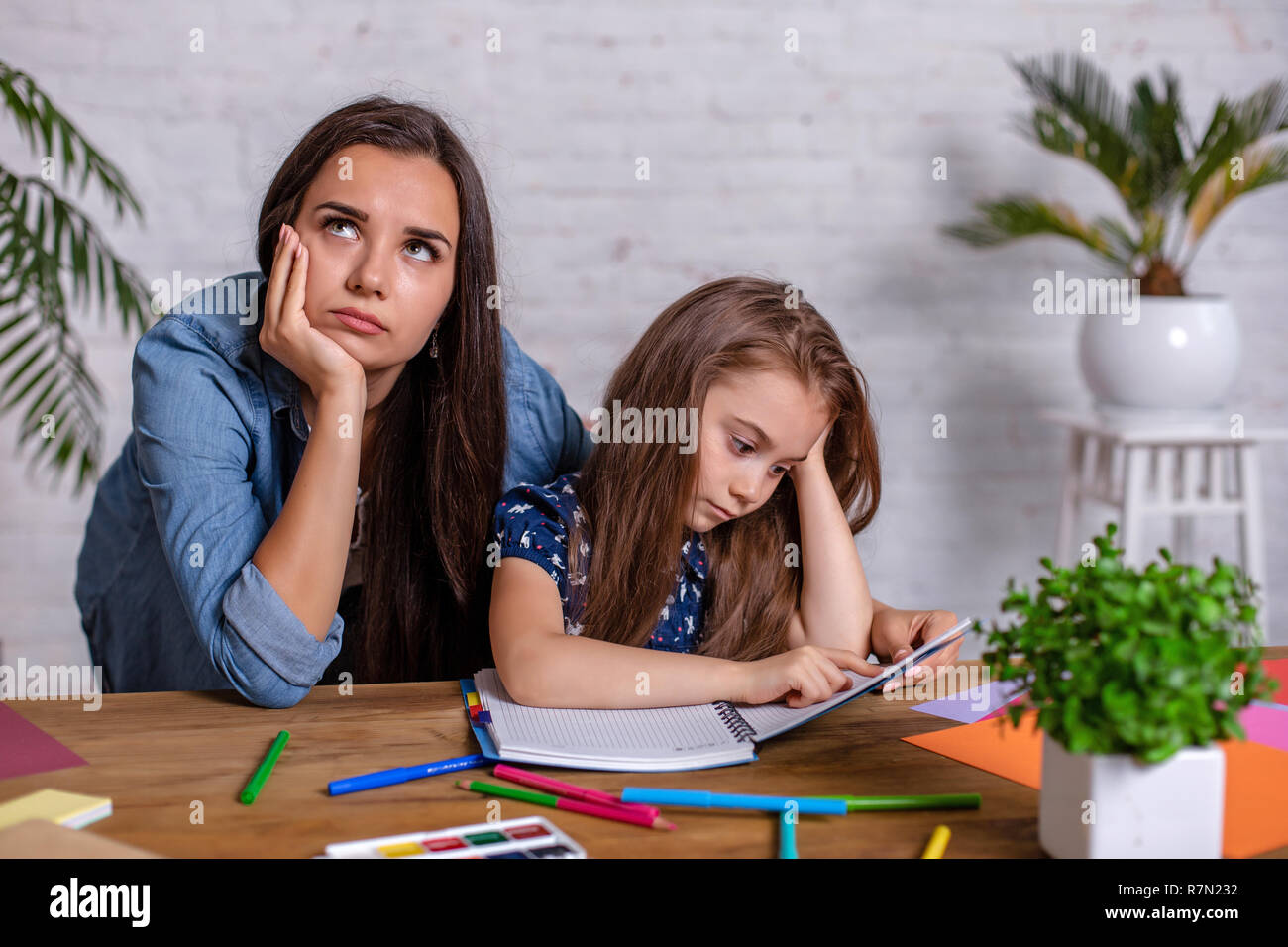 Mother becoming frustrated with daughter whilst doing homework sitting ...