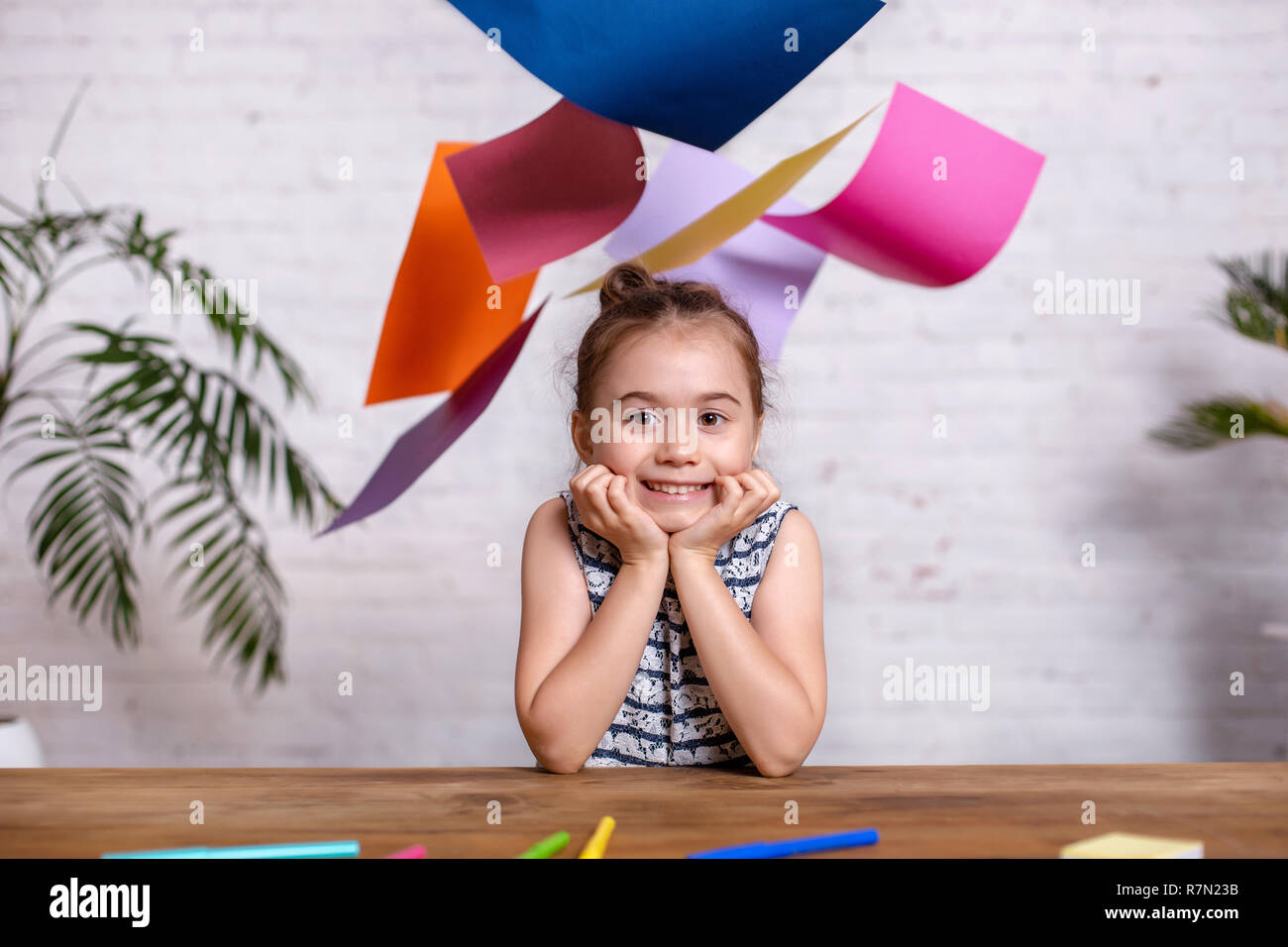 Cute little girl with the colored paper Stock Photo - Alamy
