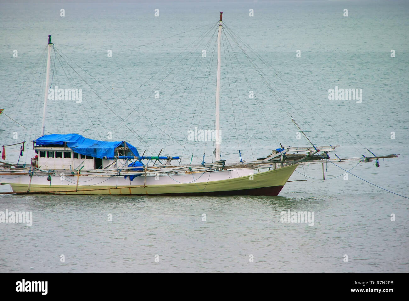 Traditional outrigger boat anchored at Labuan Bajo town on Flores ...