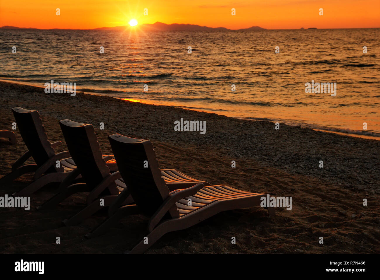 Sun chairs on sandy beach at sunrise, South Sea Island, Mamanuca group ...