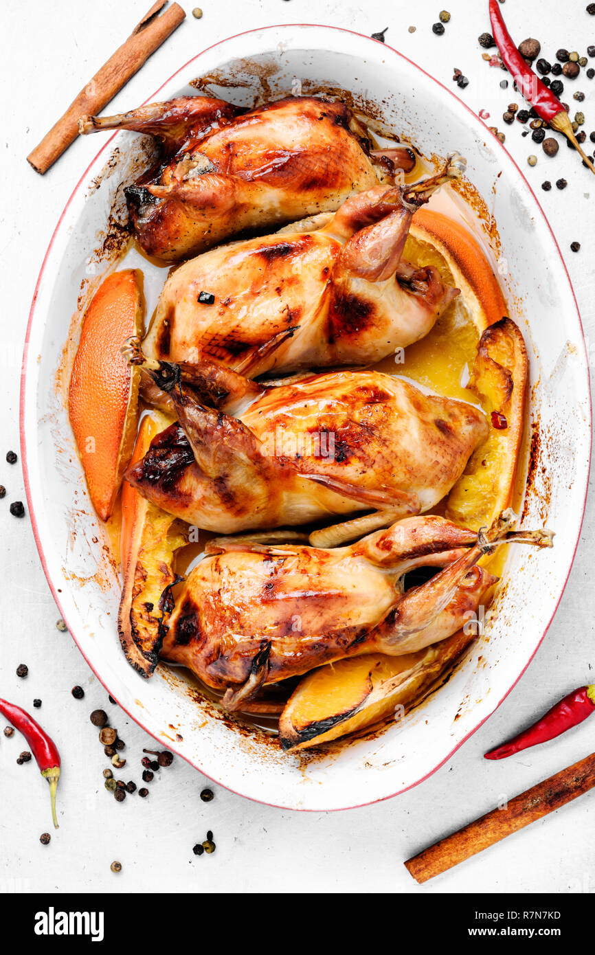 Carcasses of quail roasted with orange sauce Stock Photo - Alamy