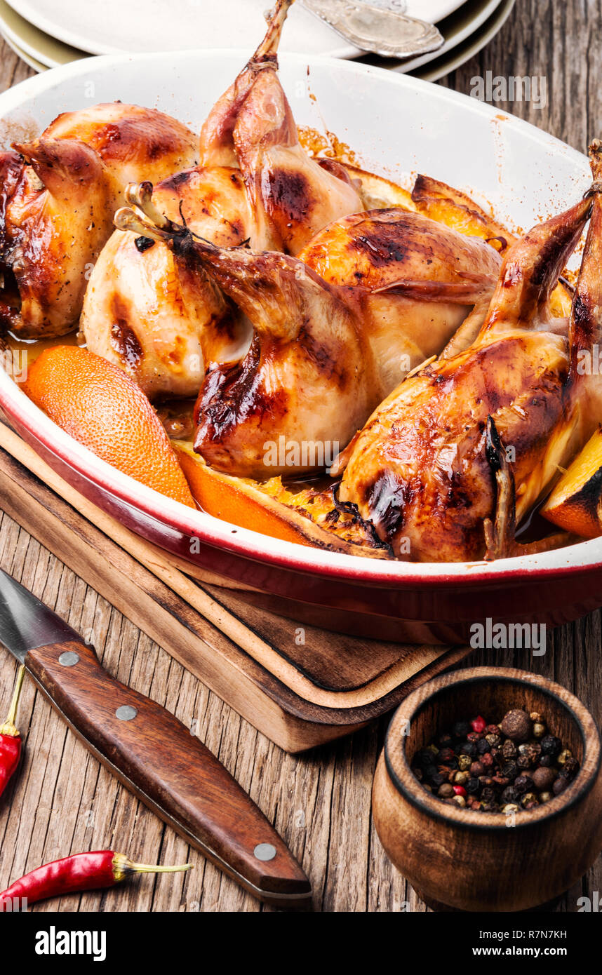 Carcasses of quail roasted with orange sauce in baking dish Stock Photo ...