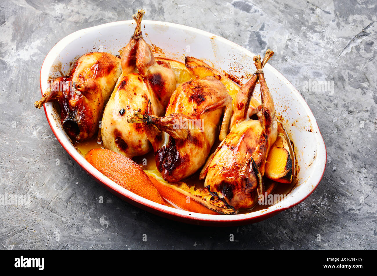 Carcasses of quail roasted with orange sauce Stock Photo - Alamy