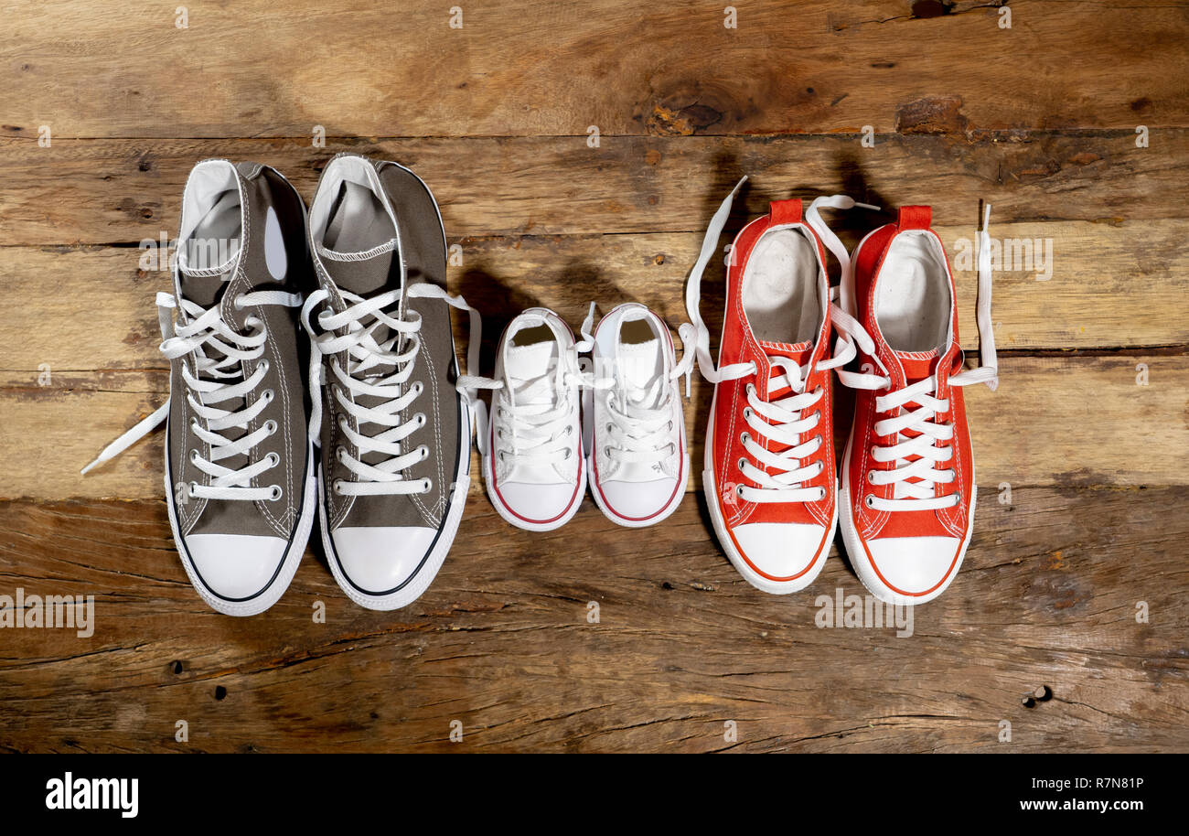 Conceptual image of gumshoes sneakers shoes of father mother and son ...
