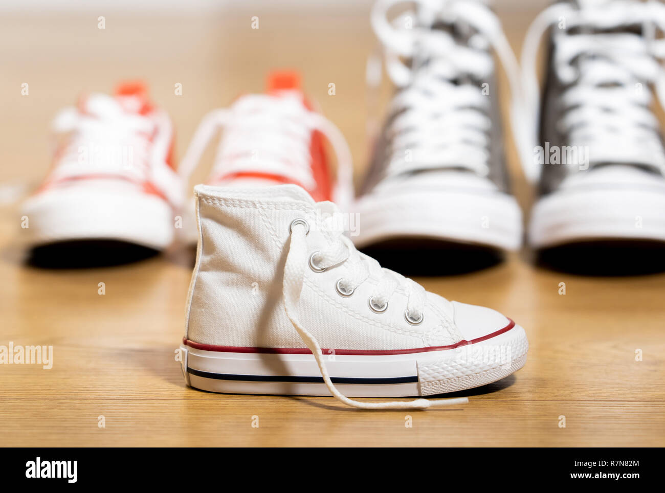 Conceptual image of gumshoes sneakers shoes of father mother and son ...