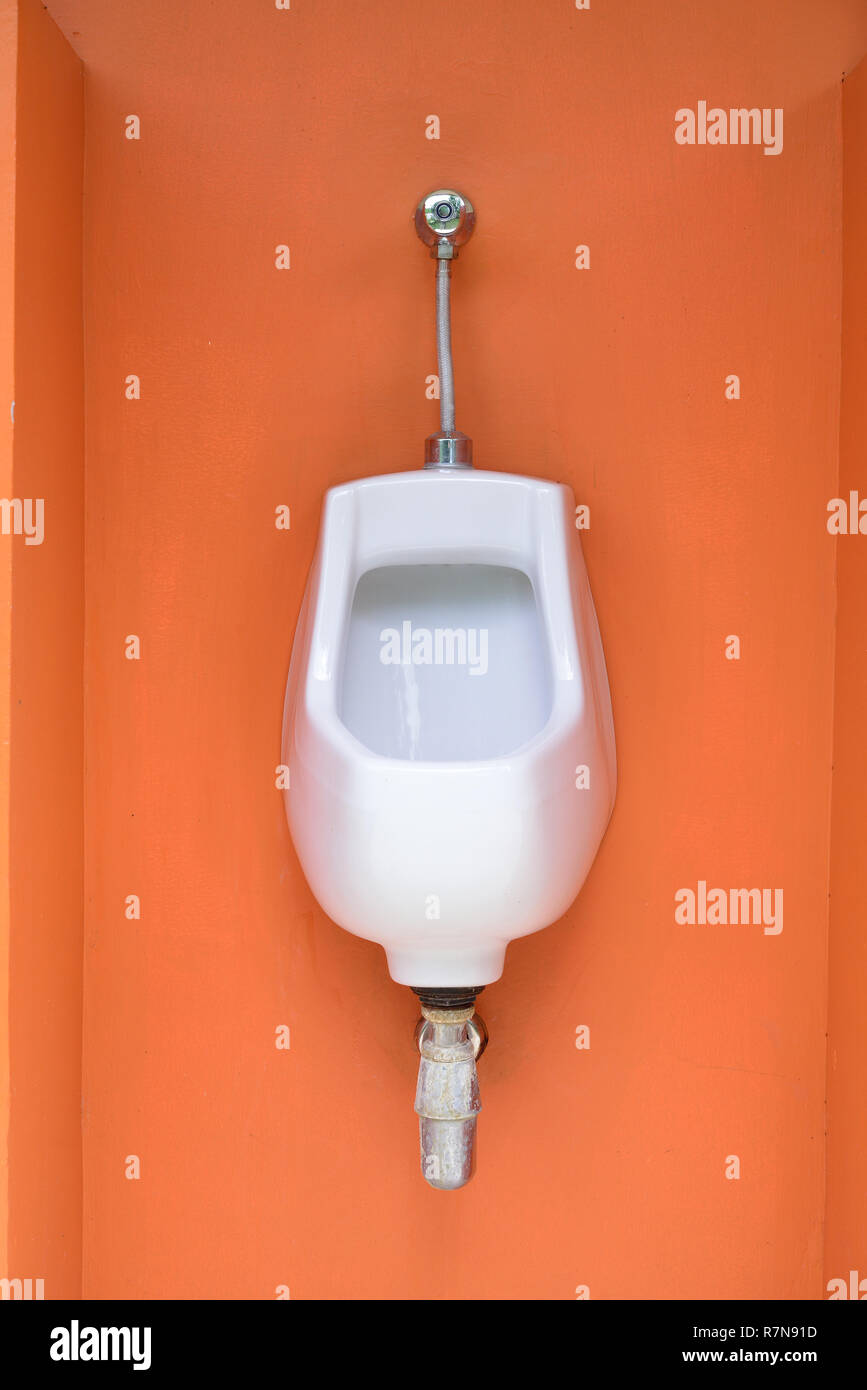 Single urinal on orange wall in public toilet Stock Photo - Alamy