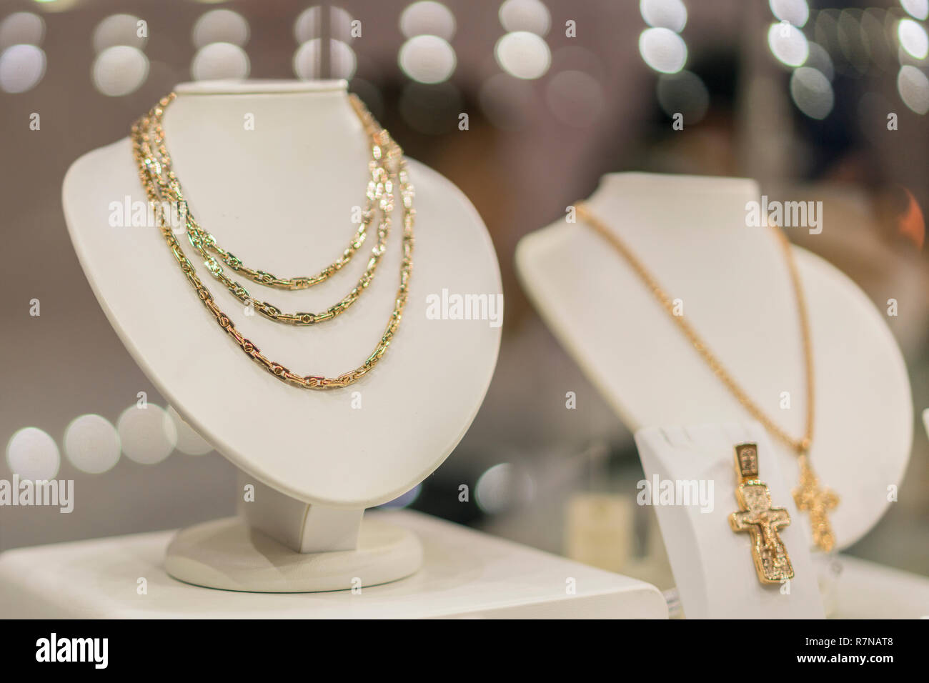 Gold necklace on the showcase Stock Photo - Alamy