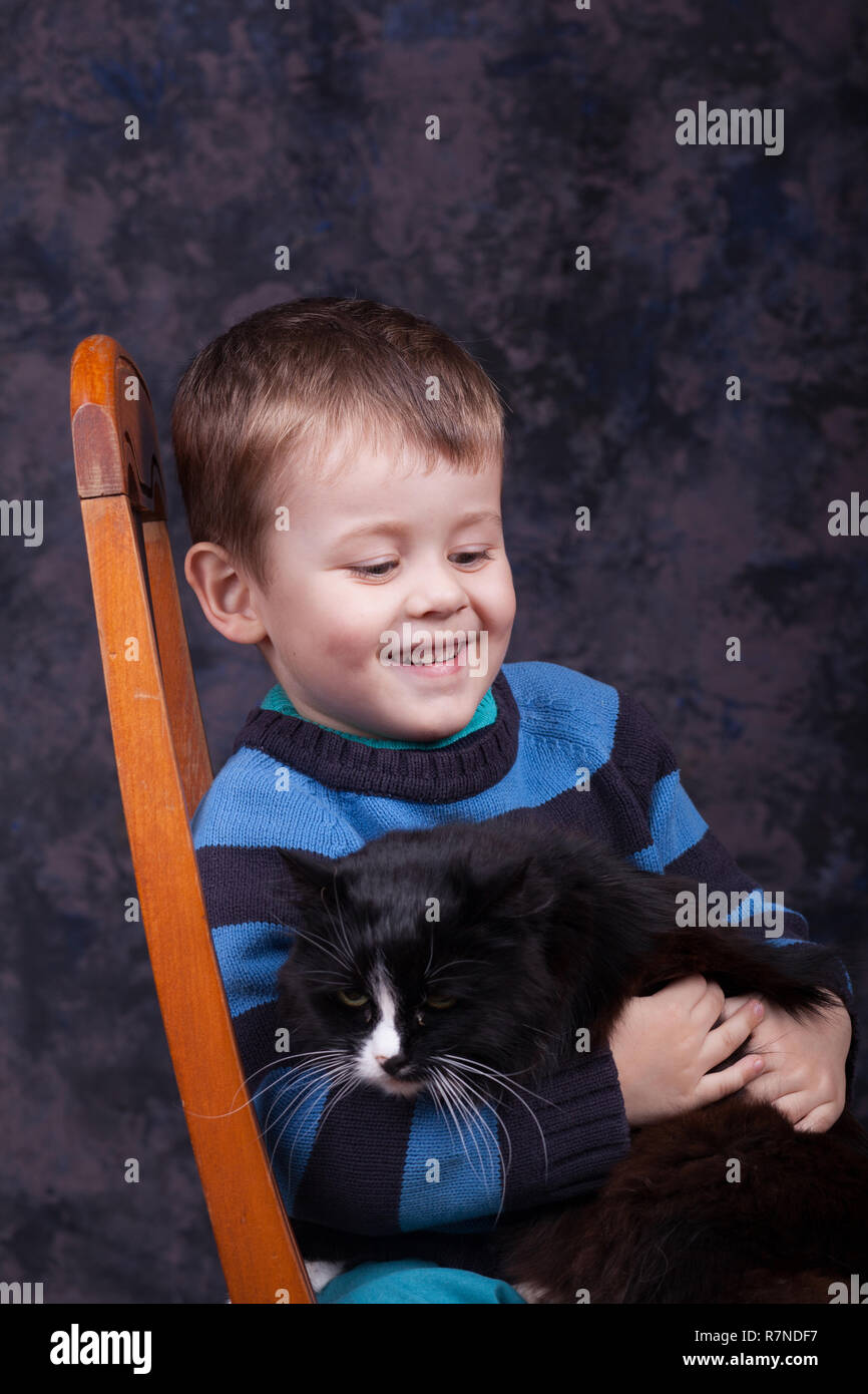 Little boy holding a black cat. Boy and kitten Stock Photo - Alamy