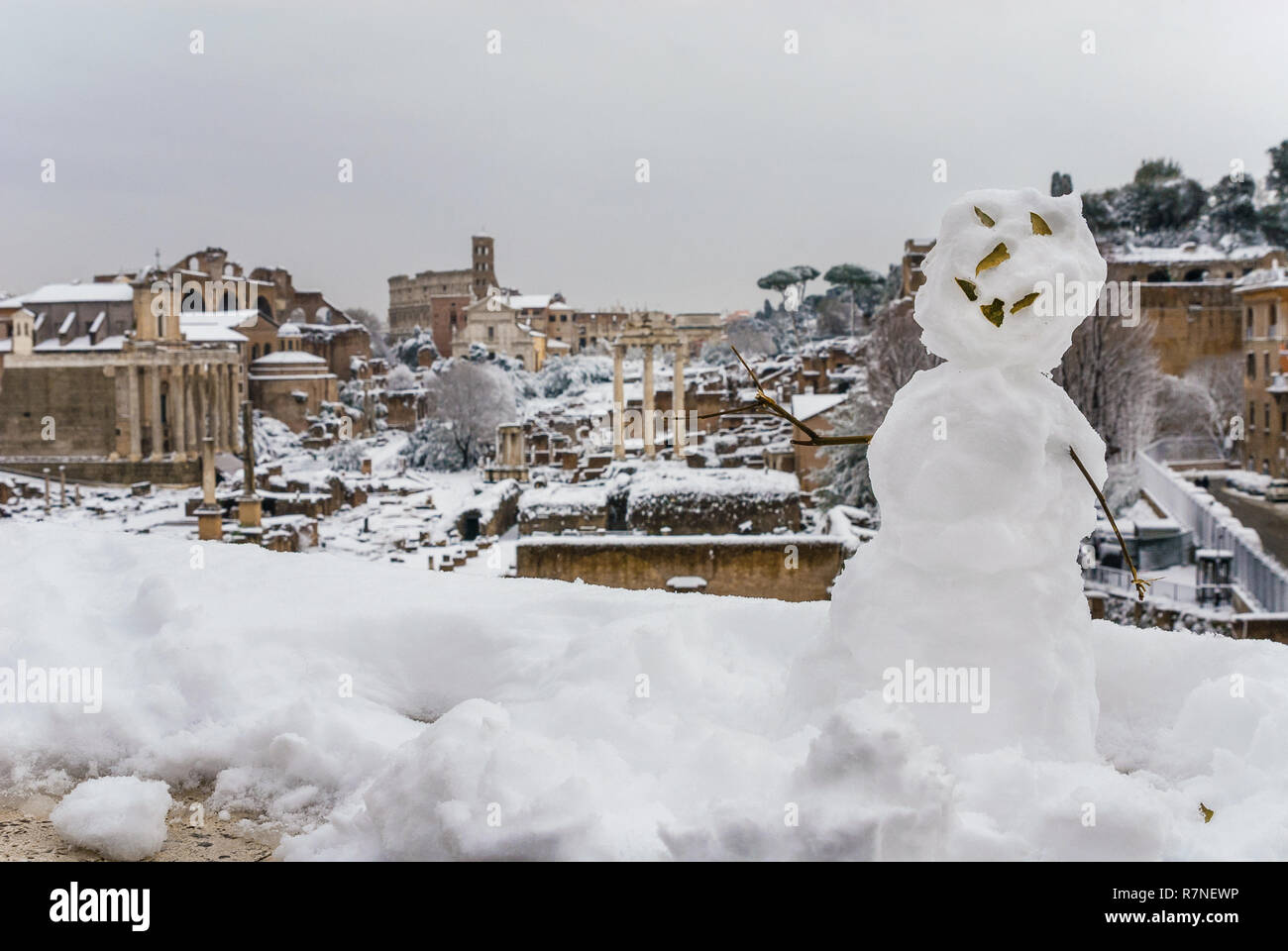 Snowman shows Roman Forum ancient monuments and Coliseum with snow ...